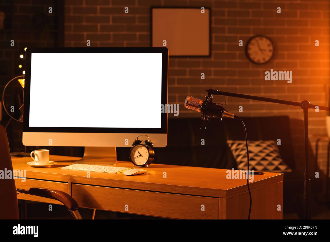 Stand with professional microphone near workplace in room at night ...