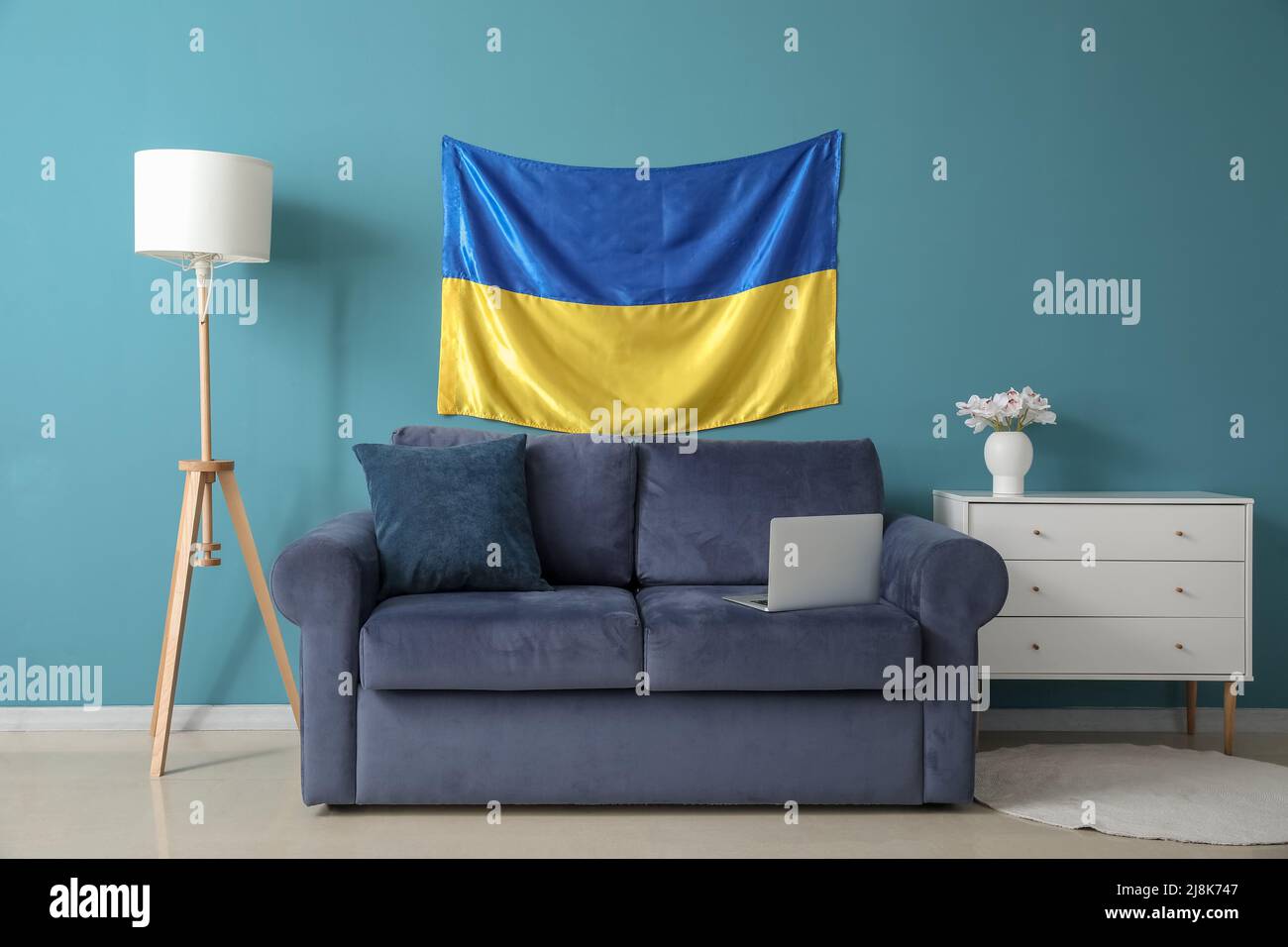 Stylish interior of living room with comfortable sofa and flag of ...