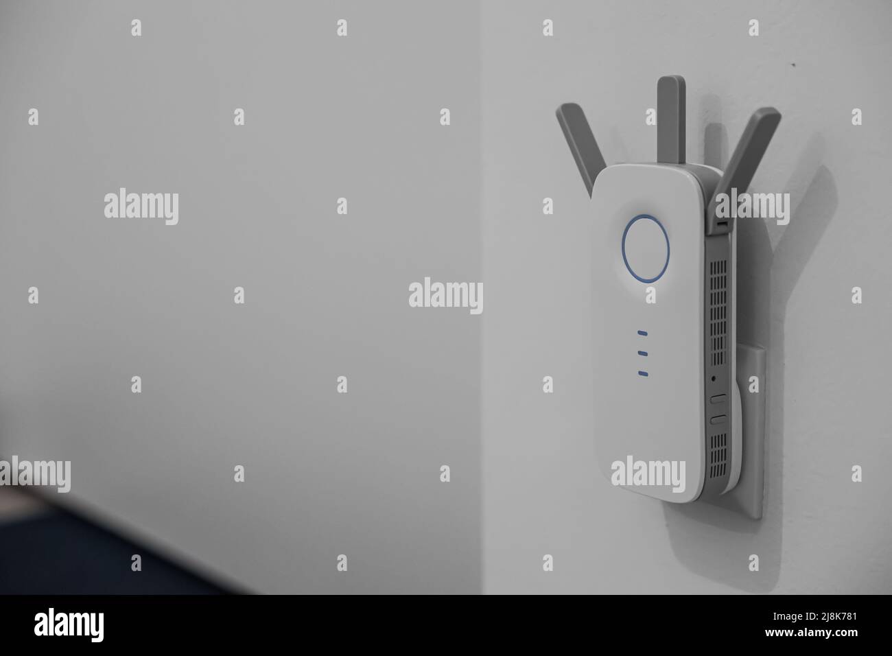 Modern wi-fi router hanging on light wall Stock Photo - Alamy