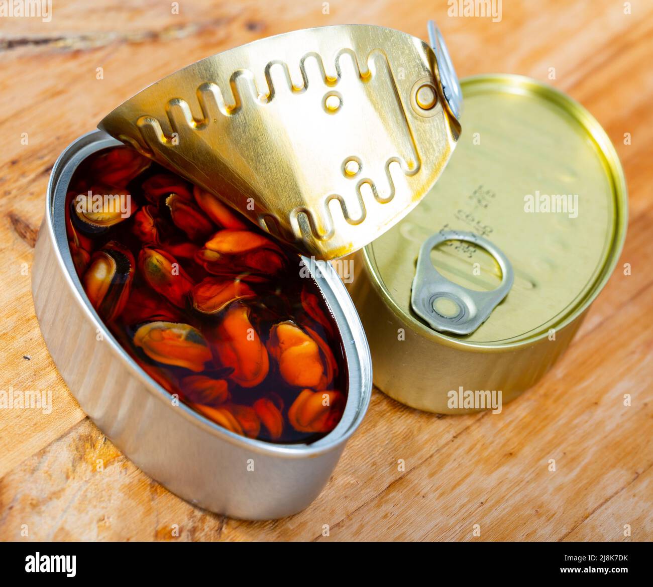Tasty sea pickled mussels in open tin can at table Stock Photo - Alamy