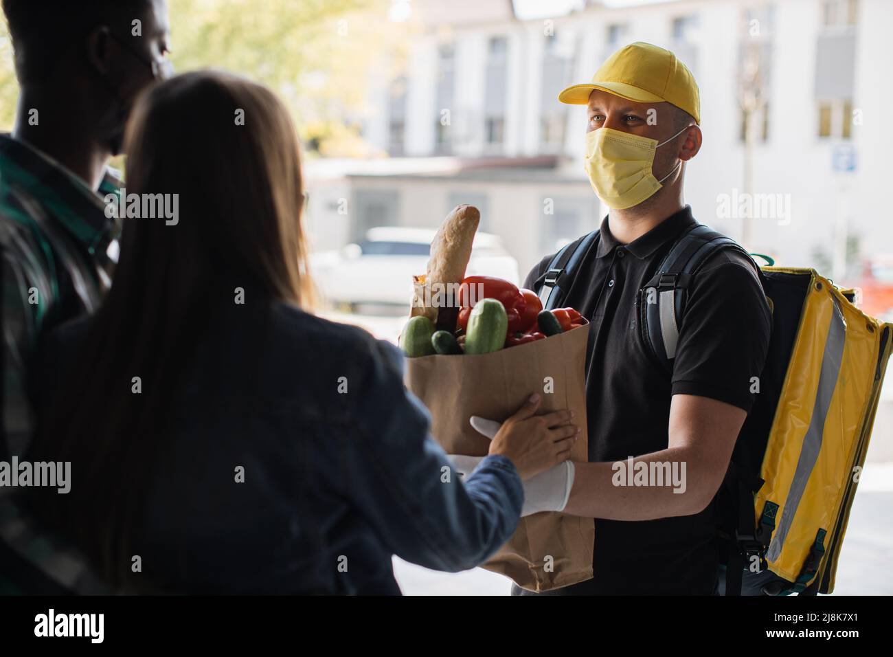 Happy food delivery man in face mask with thermal backpack delivers ...