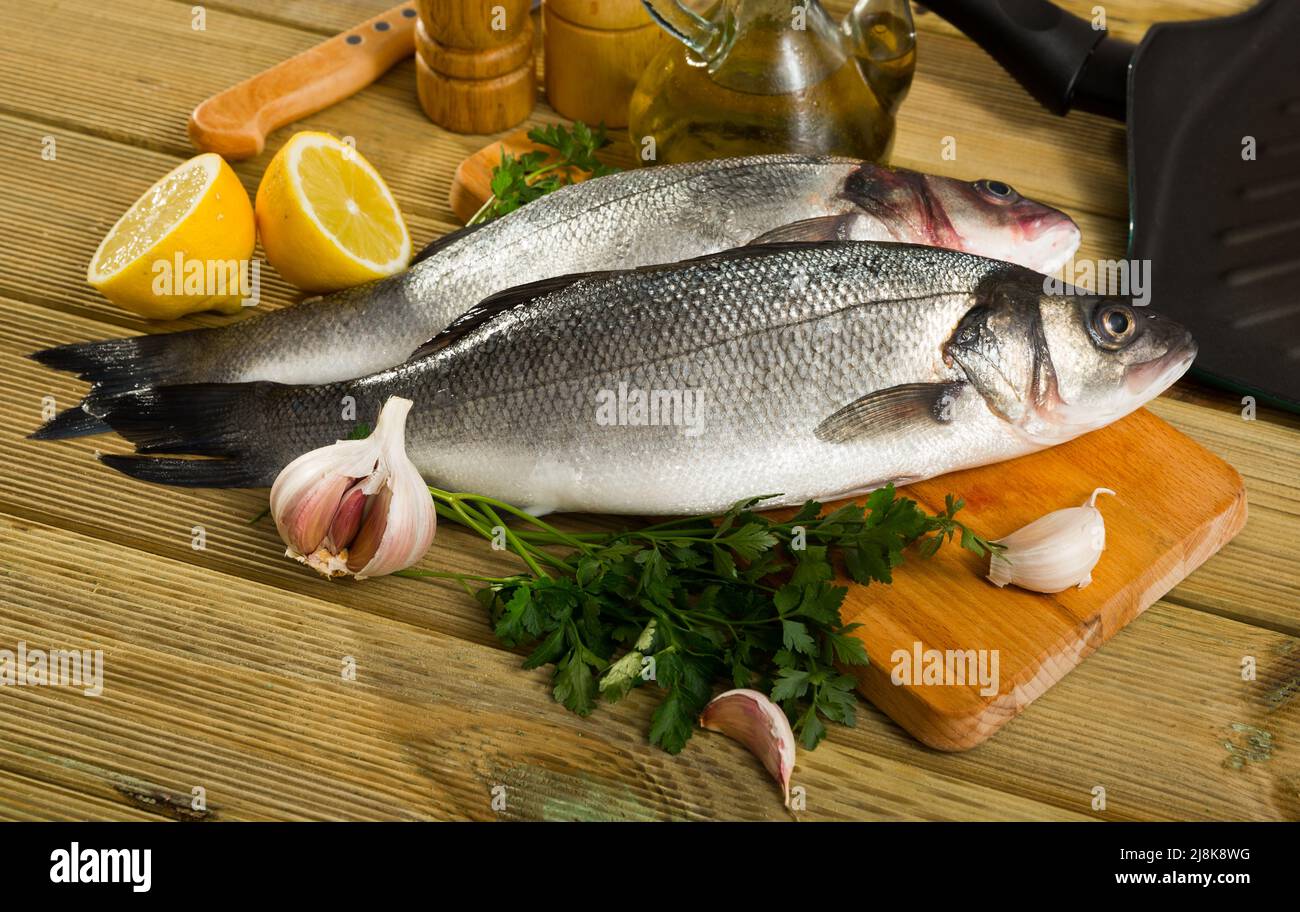 Two raw sea bass fish Stock Photo - Alamy