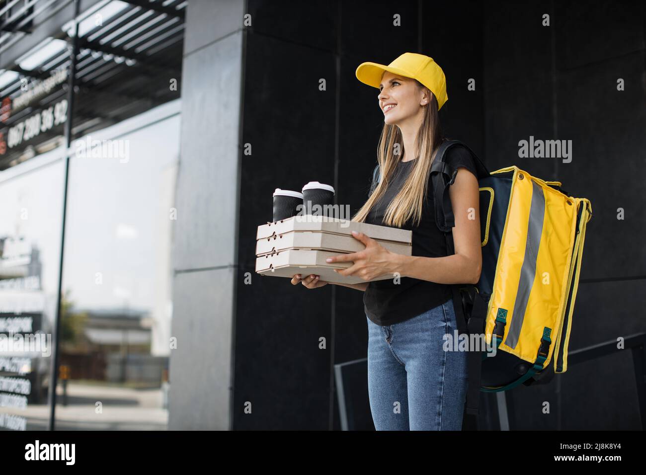 Caucasian courier delivering boxes with pizza and hot coffee. Young ...