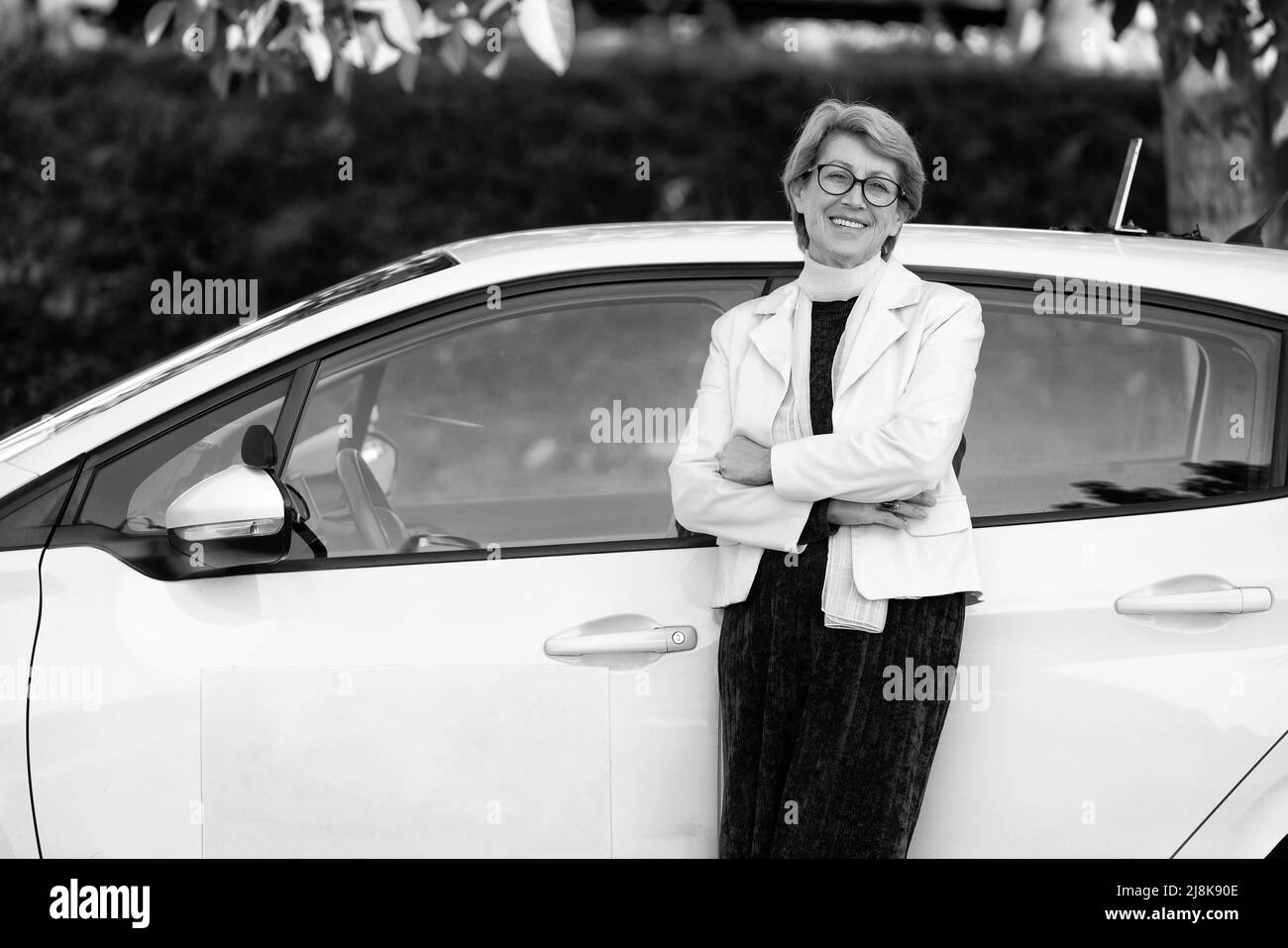 Happy Oldary Woman Instructor Leaning on Her Car - Presumably She Has a ...