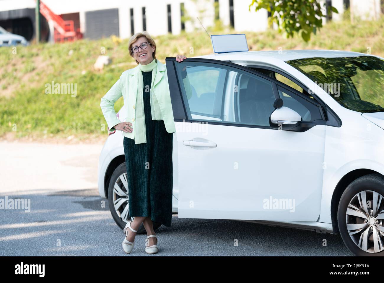 Happy Oldary Woman Instructor Leaning on Her Car - Presumably She Has a ...