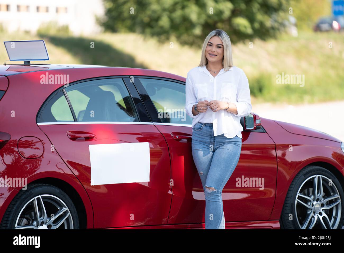 Happy Woman Instructor Leaning on Her Car - Presumably She Has a Break ...