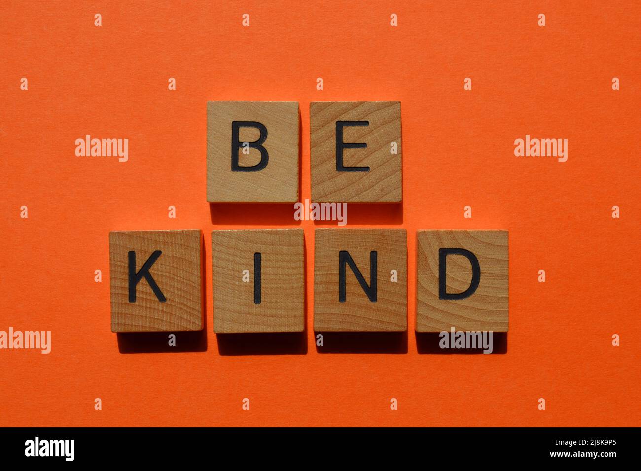 Be Kind, words in wooden alphabet letters isolated on bright orange ...