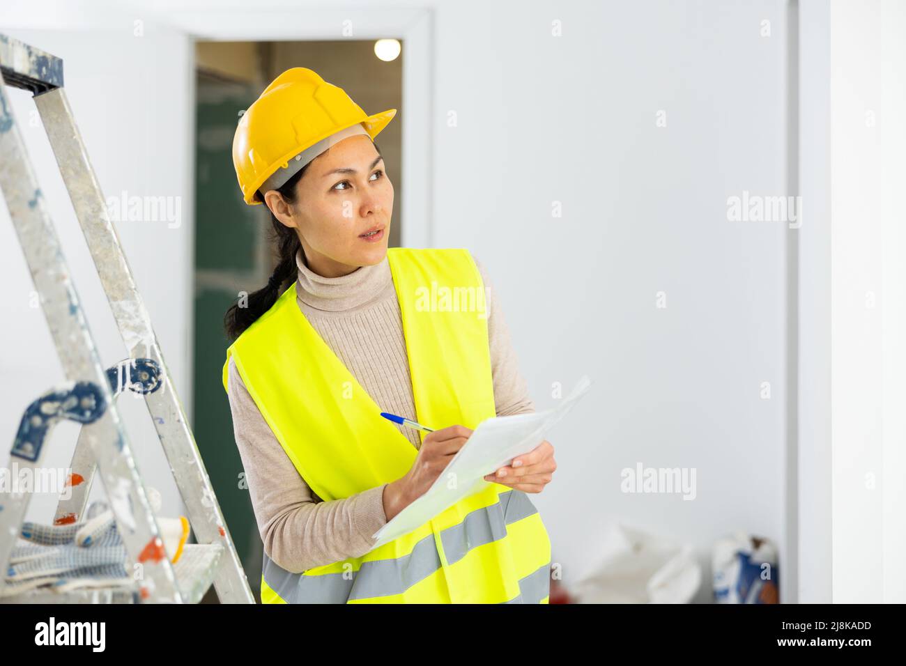 Woman engineer checking documents during repair works indoors Stock ...