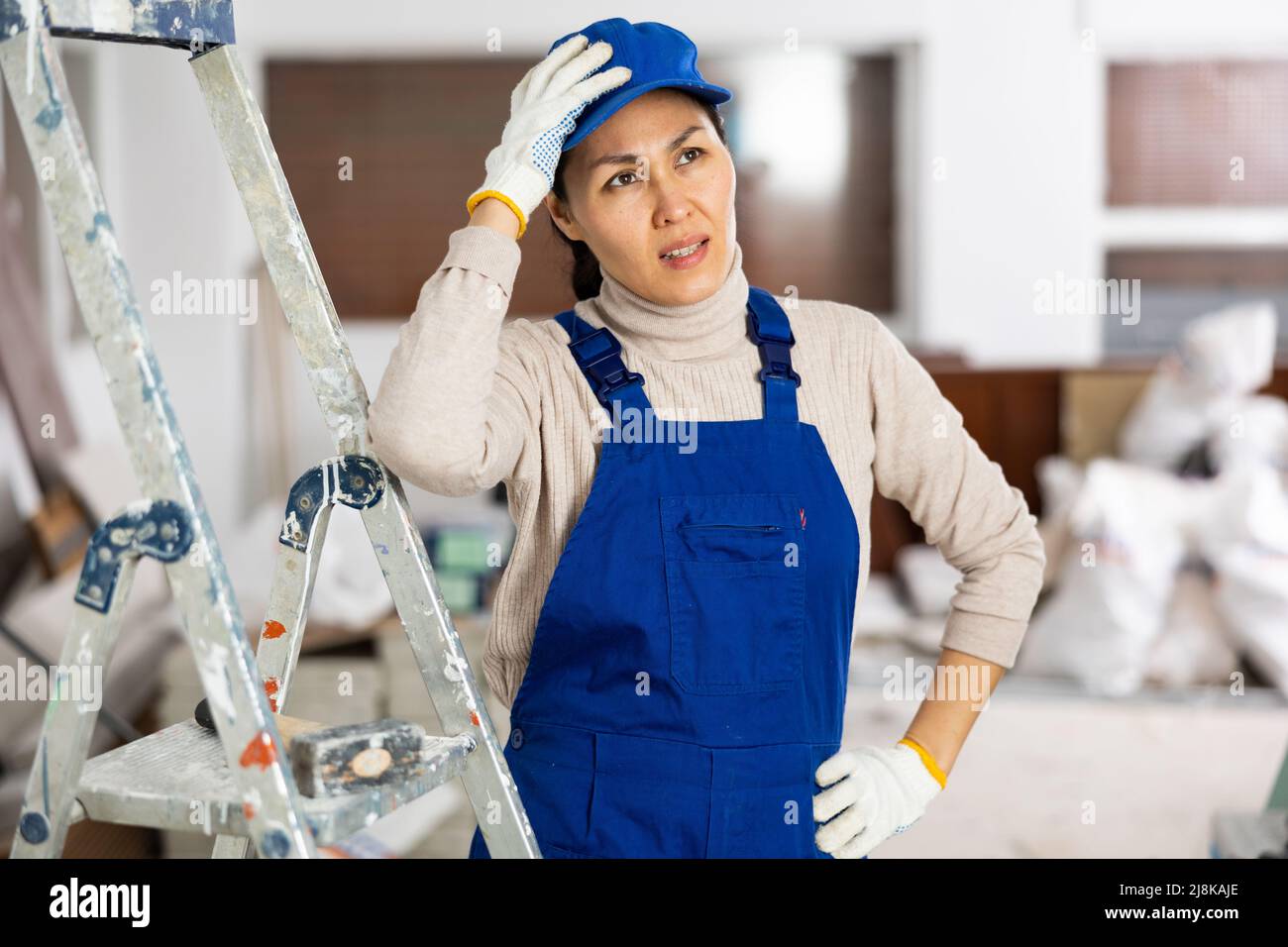 Disappointed woman builder standing in construction site Stock Photo ...