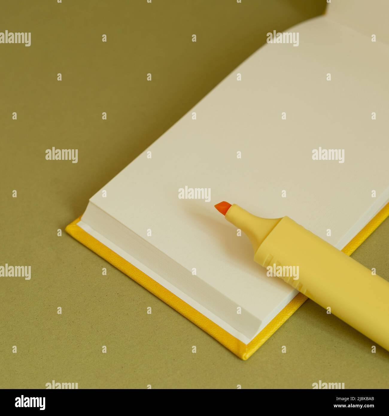 Open blank notebook and yellow highlighter on desk Stock Photo - Alamy