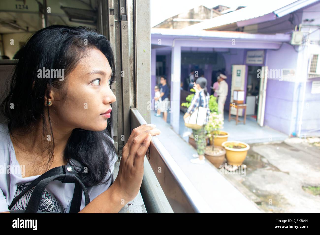 A passenger looks out the train window at the train station Stock Photo ...