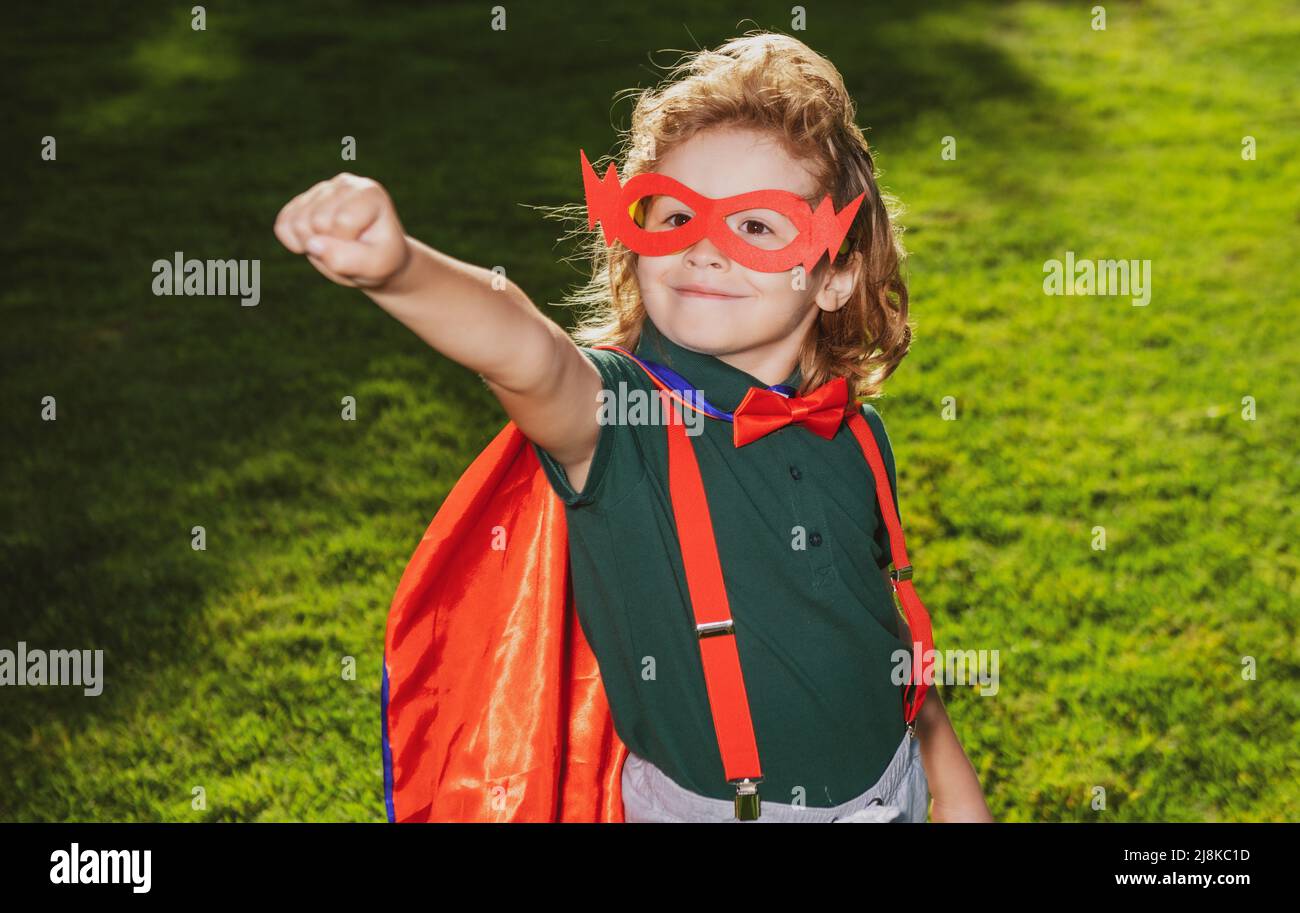 Superhero child against spring green field outdoor. Freedom and ...