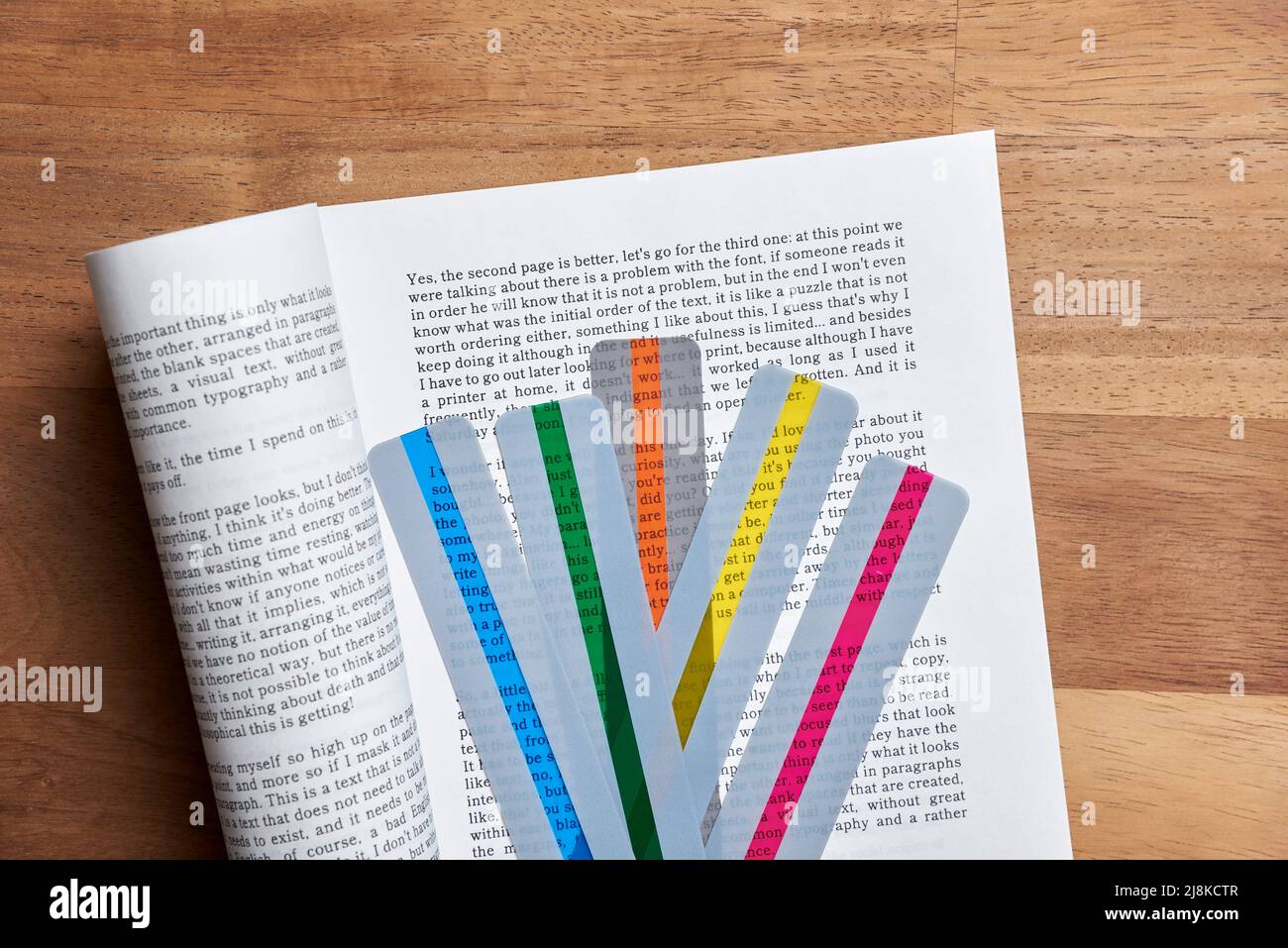 Pack of different colors reading rulers over an open textbook, coloured ...