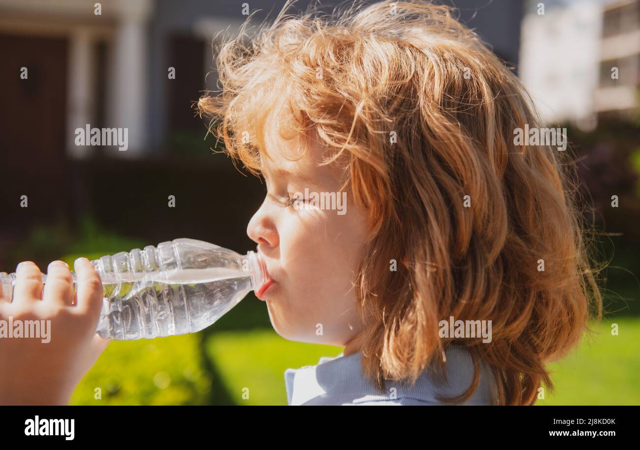 Portrait of a cute child boy drinking water from bottle. Close up ...
