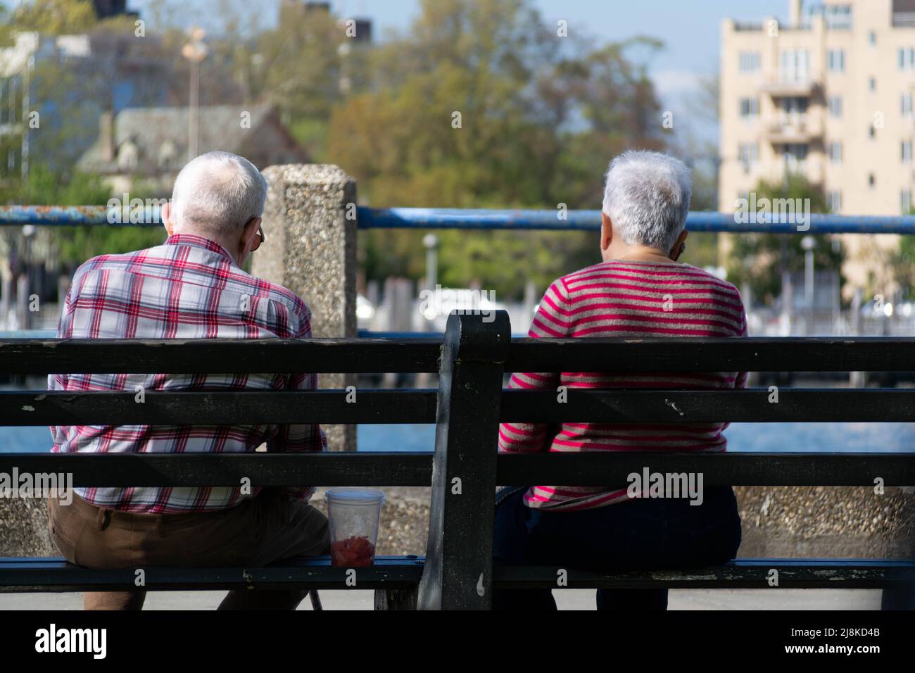 Two senior citizens are sitting on the bench by the Sheepshead bay ...