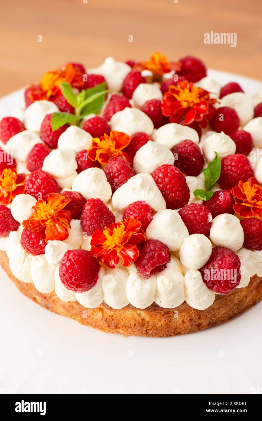 Keto Vanilla Sponge Cake with Raspberries, marigold flowers and fresh ...