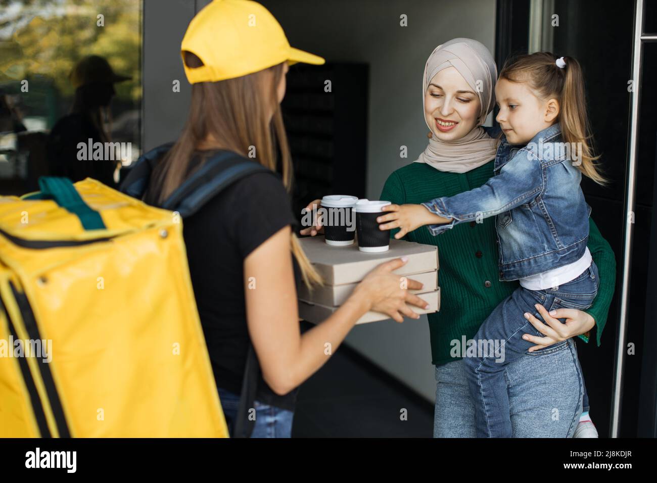 Happy food delivery woman wearing thermal backpack delivers pizza order ...