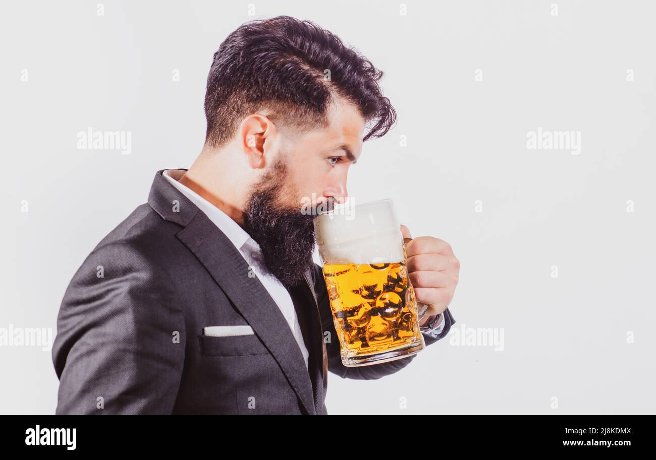 Man in classic suit drinking beer. Bearded guy in business outfit looks ...