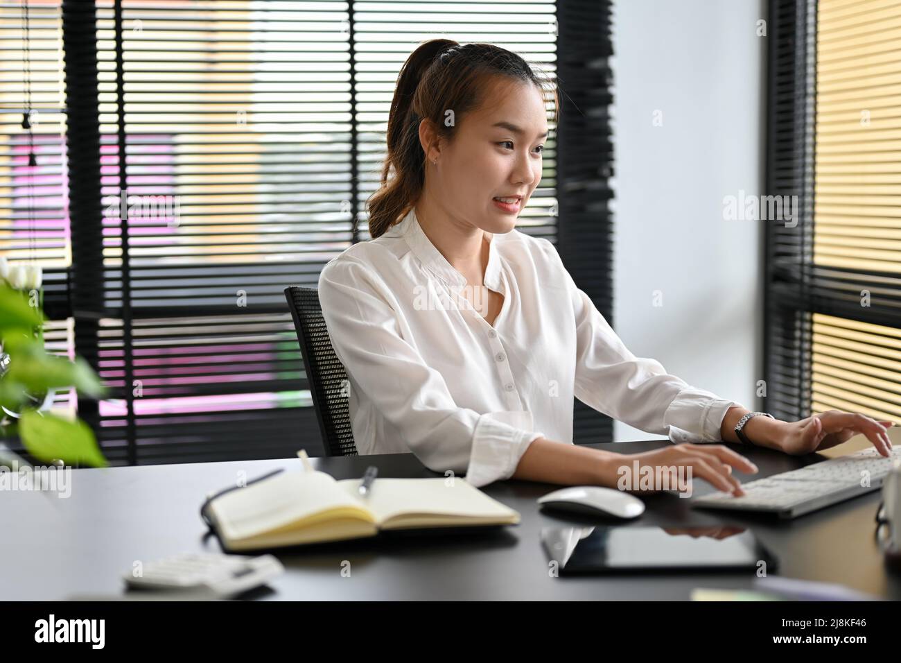 Elegant Asian businesswoman or female manager working at her office ...