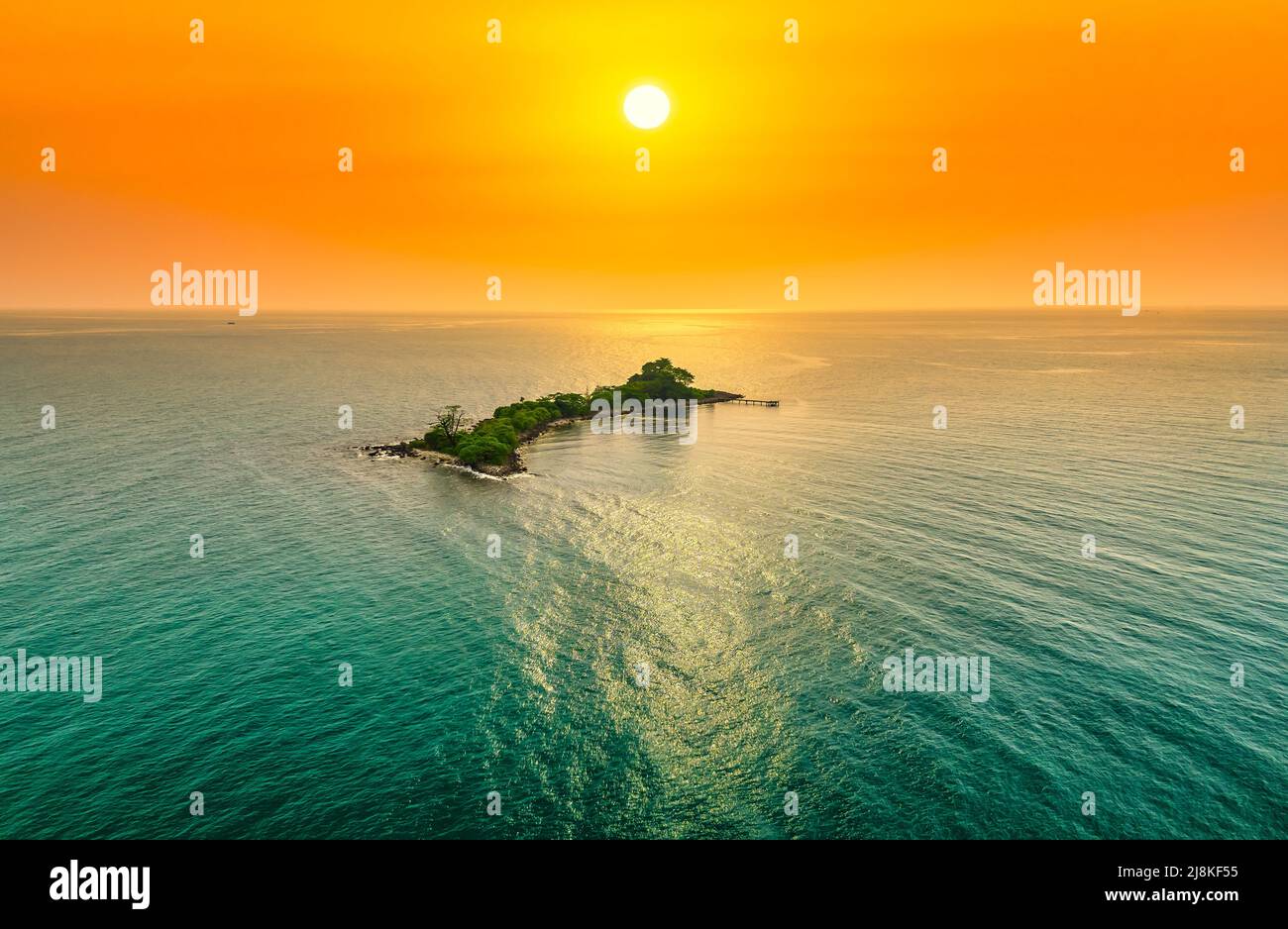 Aerial view of a desert island in a turquoise water and sunset sky ...