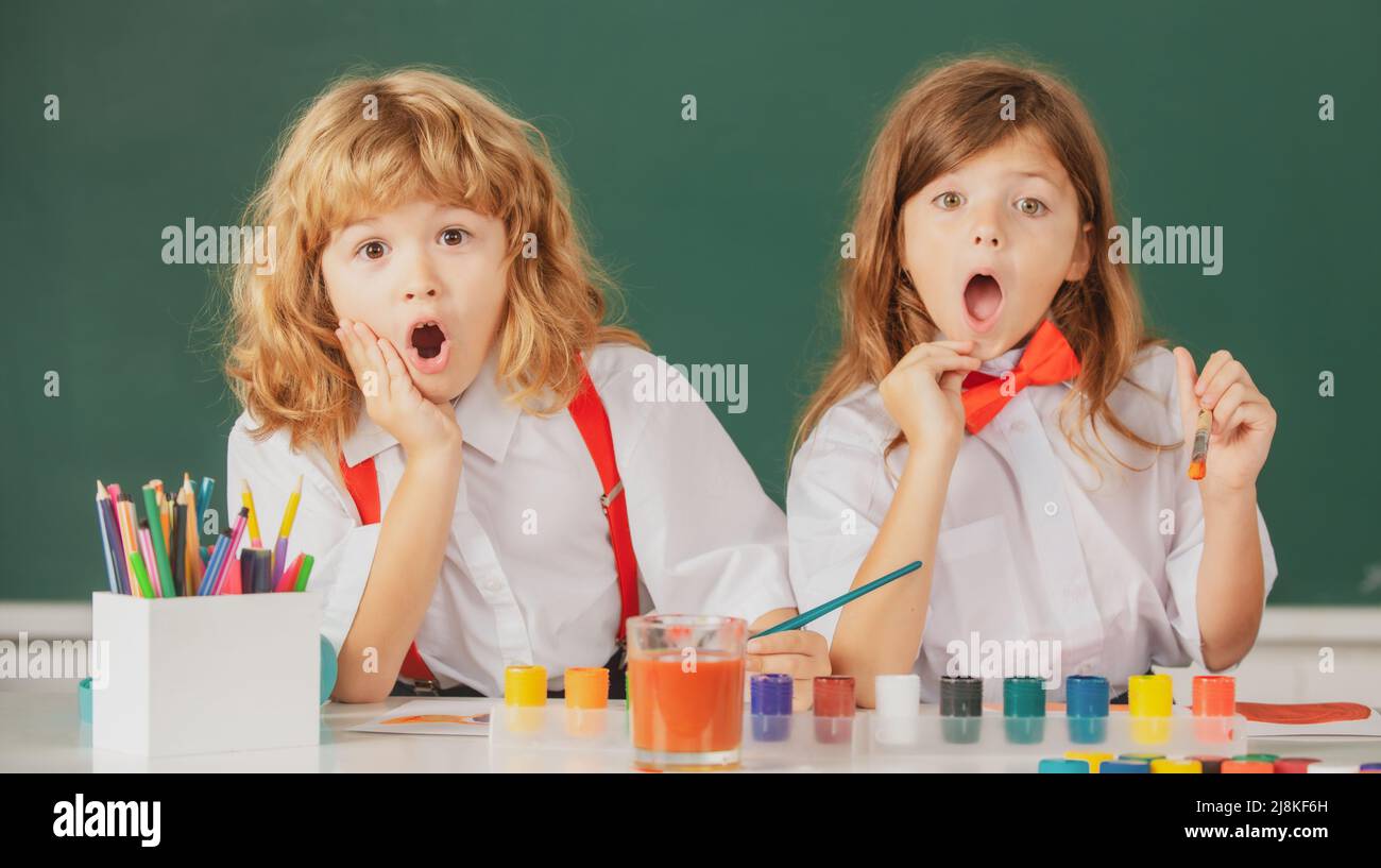 Excited school surprised children drawing a colorful pictures with ...