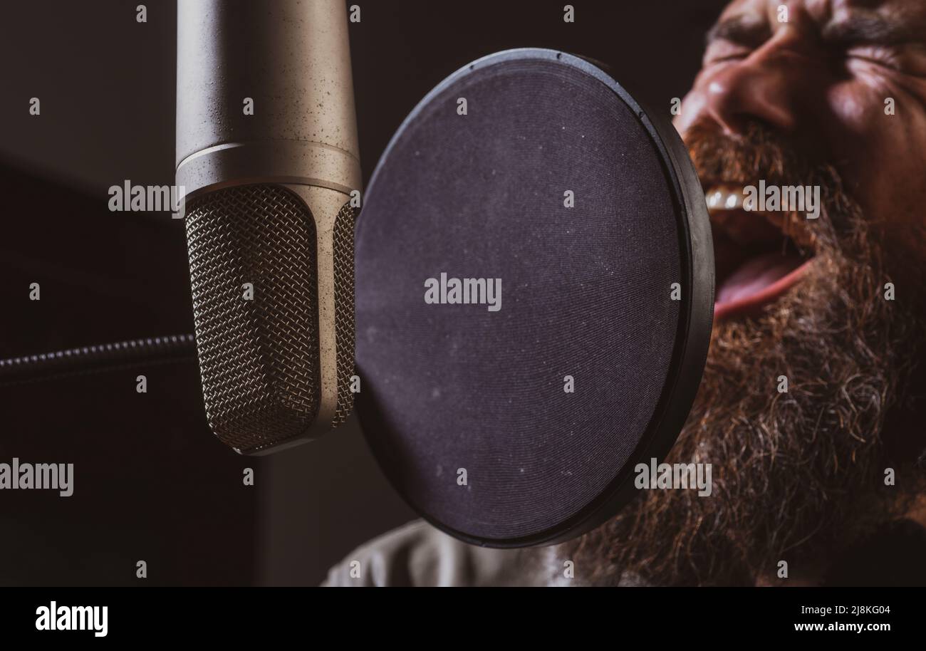 Singer with expressive face closeup wearing headphones is performing a ...