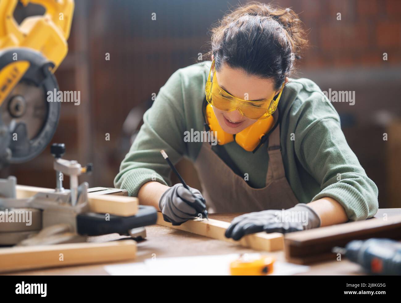 Young woman is training to be a carpenter in workshop Stock Photo - Alamy