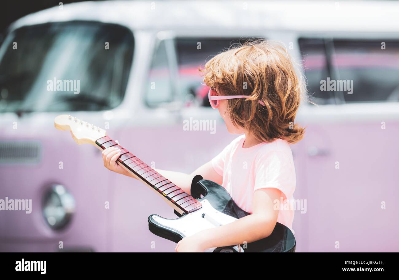 Rock and roll child. Portrait of cute boy playing a guitar. Music ...