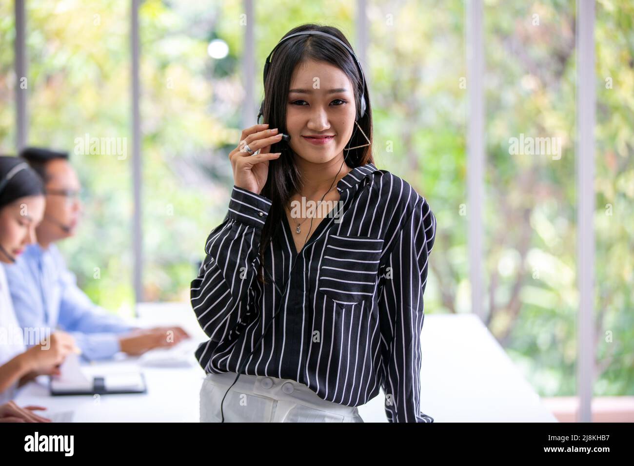 Team of diverse hotline operators with headphones providing service to ...