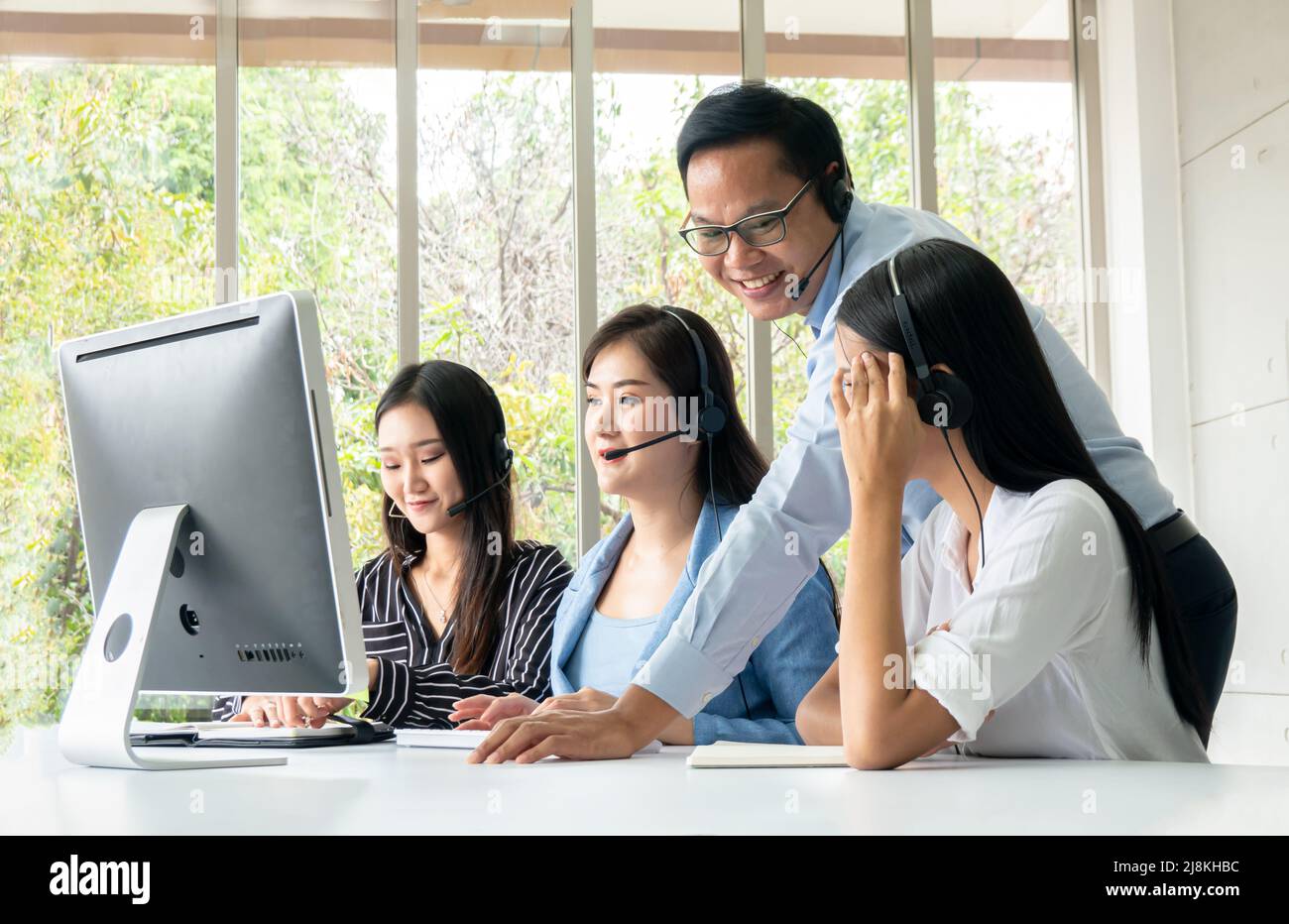 Team of diverse hotline operators with headphones providing service to ...