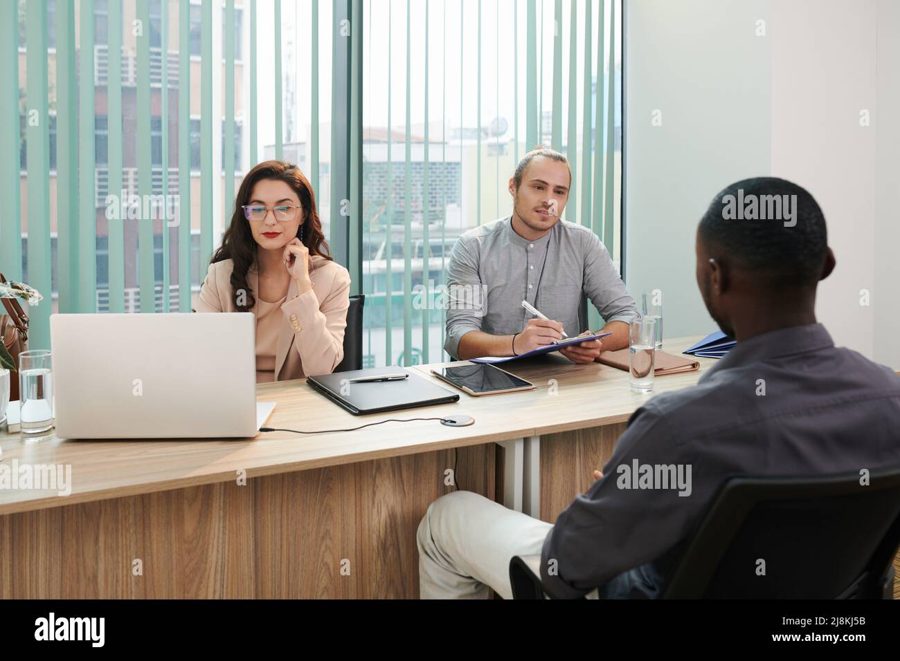 HR manager filling form on laptop when employer asking applicant some ...