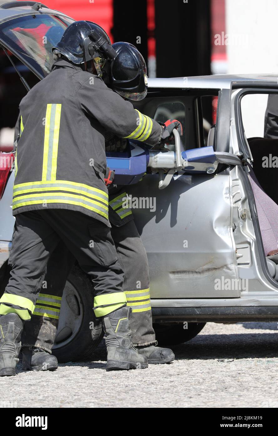 firefighters cutting the sheets of the crashed car with a powerful ...