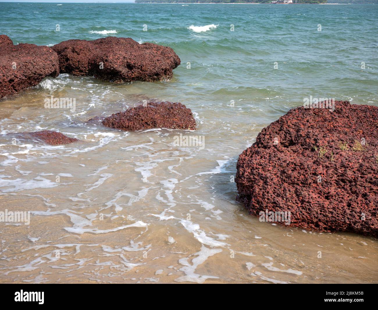 Sea waves and Laterite rock (Red Jambha stone) on Bhowe beach state ...