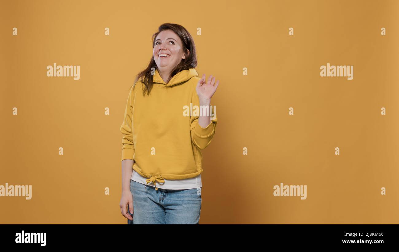 Young woman posing shy feeling embarrassed and awkward asking please ...