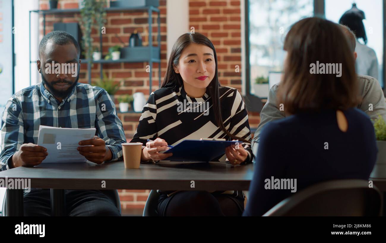 Diverse group of employees talking to applicant at job interview ...