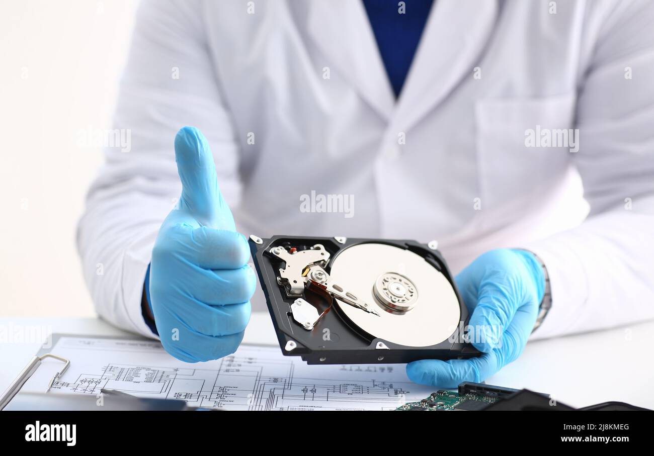 Man in uniform hold disassembled hard drive from computer, hdd and ...
