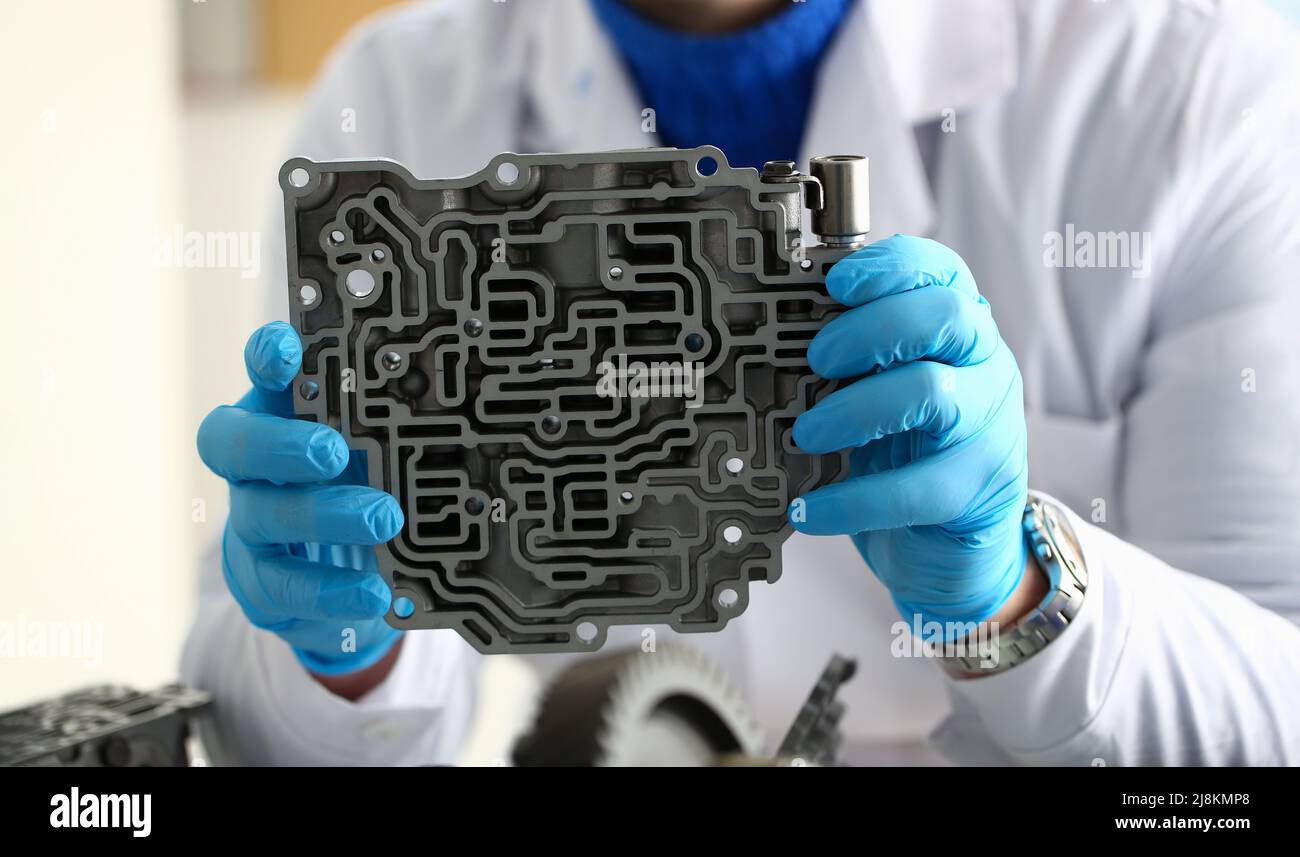 Handyman in gloves hold automobile part, male mechanic show car detail ...