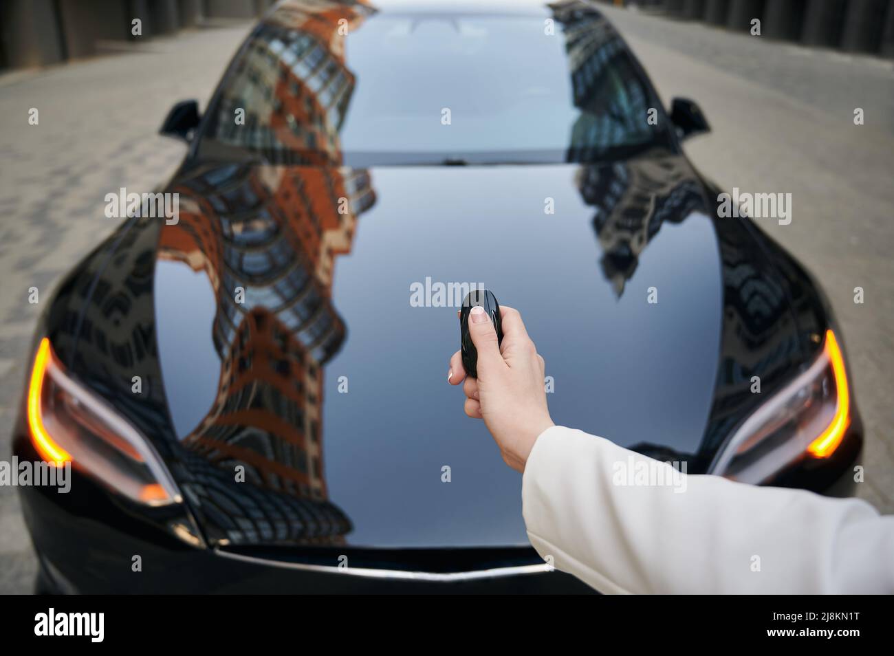 Women's hand pressing on remote control automobile alarm systems ...