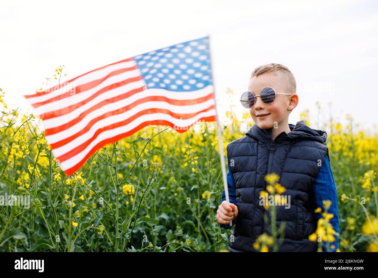 Closeup of a young patriotic boy stands among field. Boy standing with ...