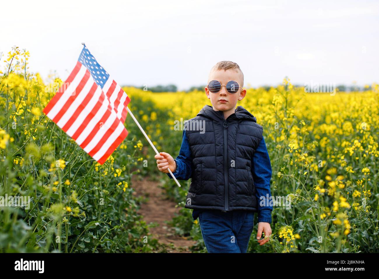 Closeup of a young patriotic boy stands among field. Boy standing with ...