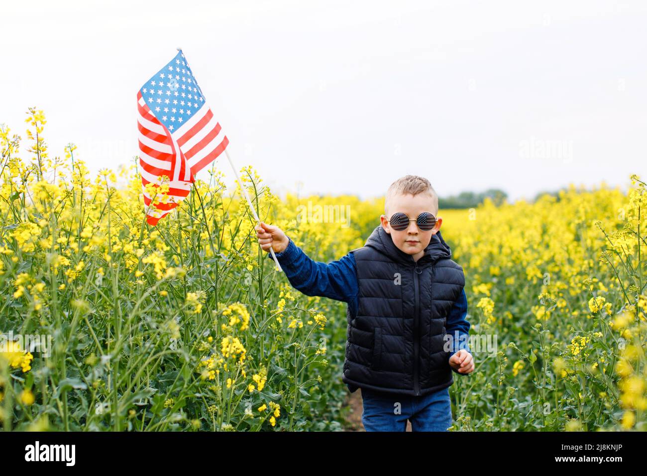 Closeup of a young patriotic boy stands among field. Boy standing with ...