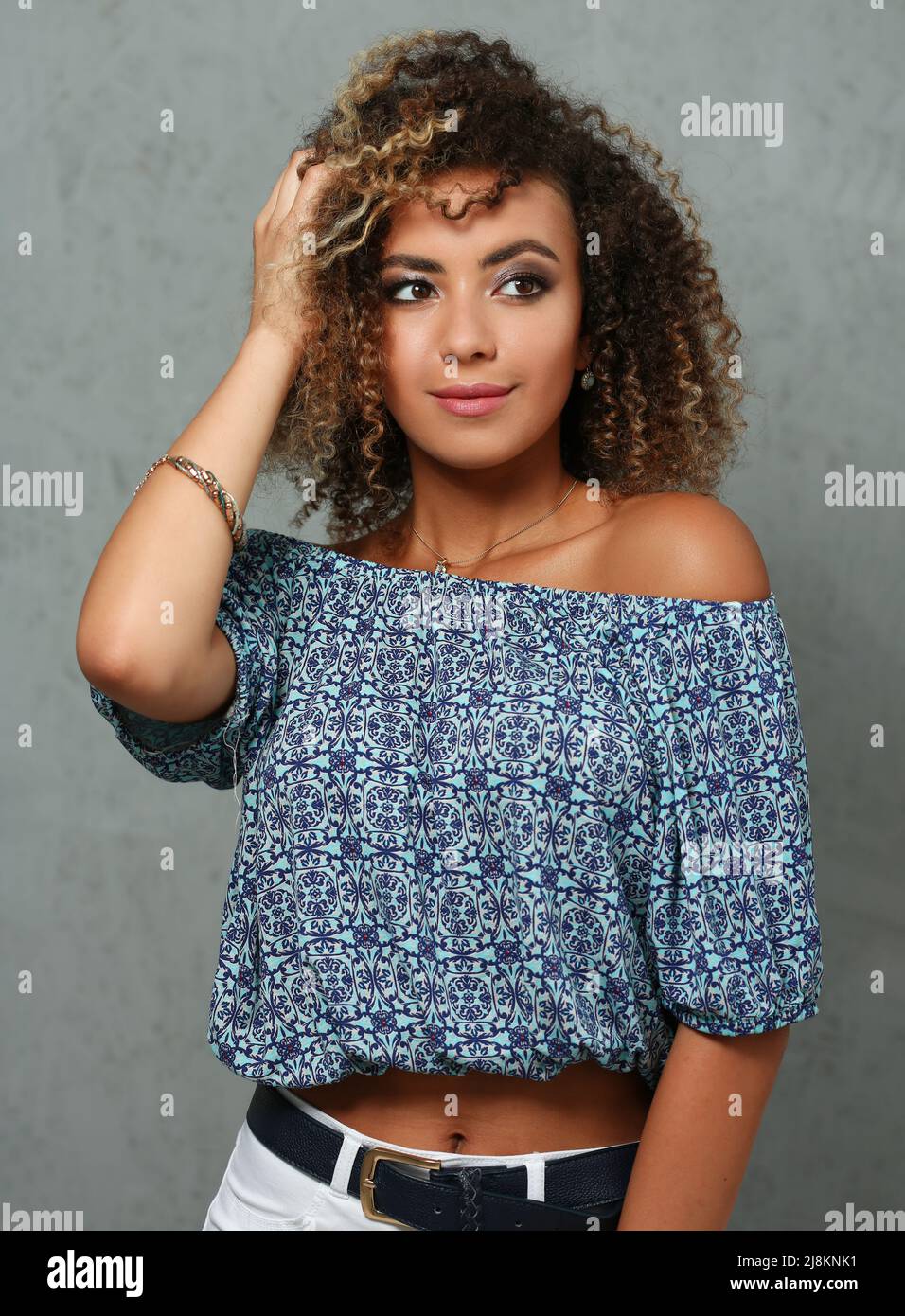 Charming young lady with exotic appearance, woman with curly hairstyle ...