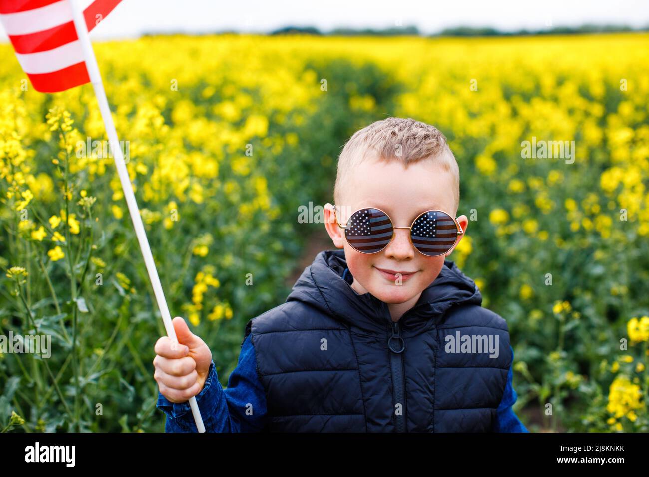 Closeup of a young patriotic boy stands among field. Boy standing with ...