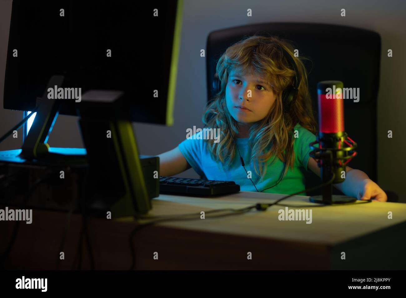 Child plays a video game on the pc computer screen. Gamer play computer ...