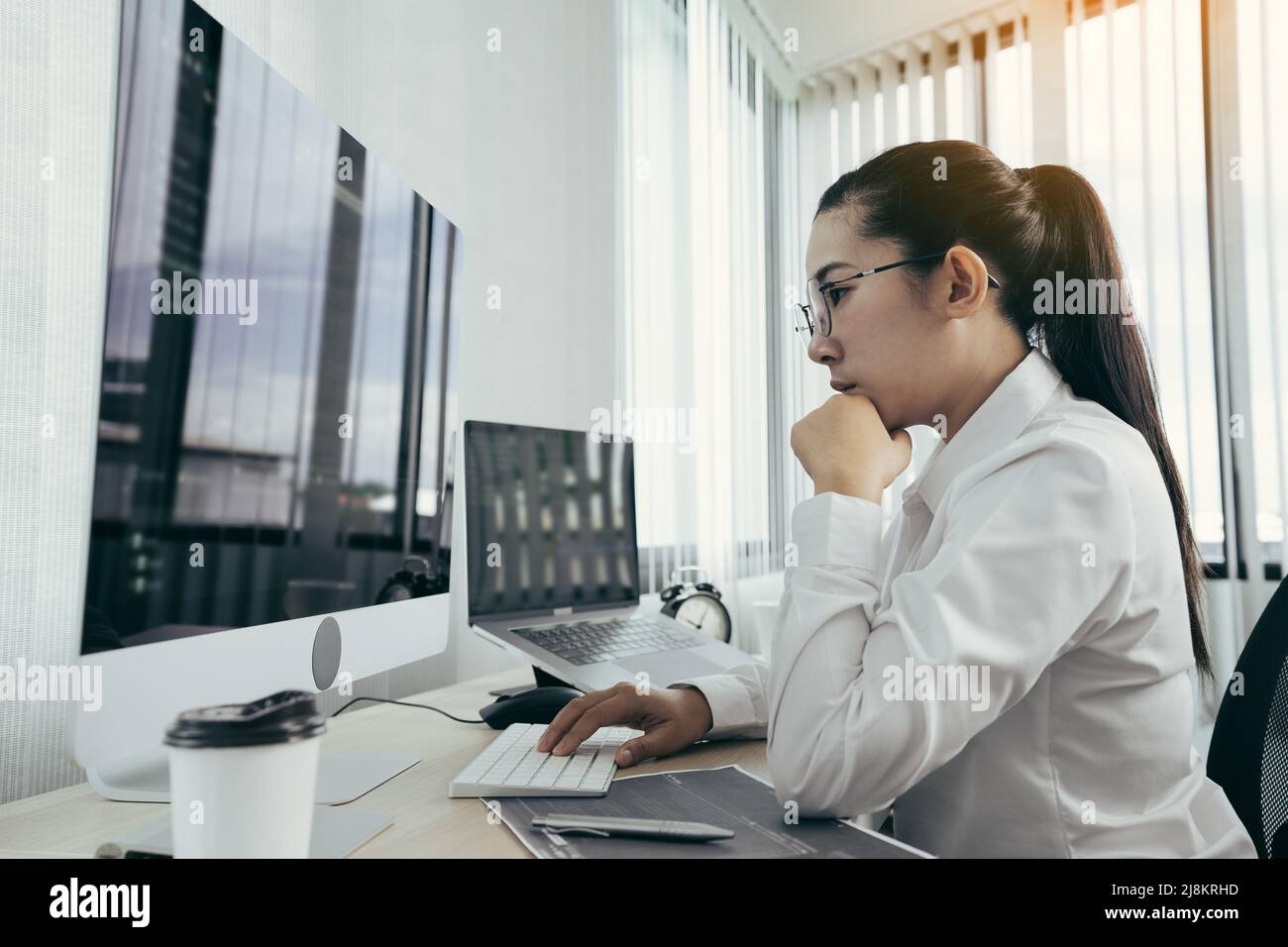 Asian female software developer is worried about analyzing code-based ...