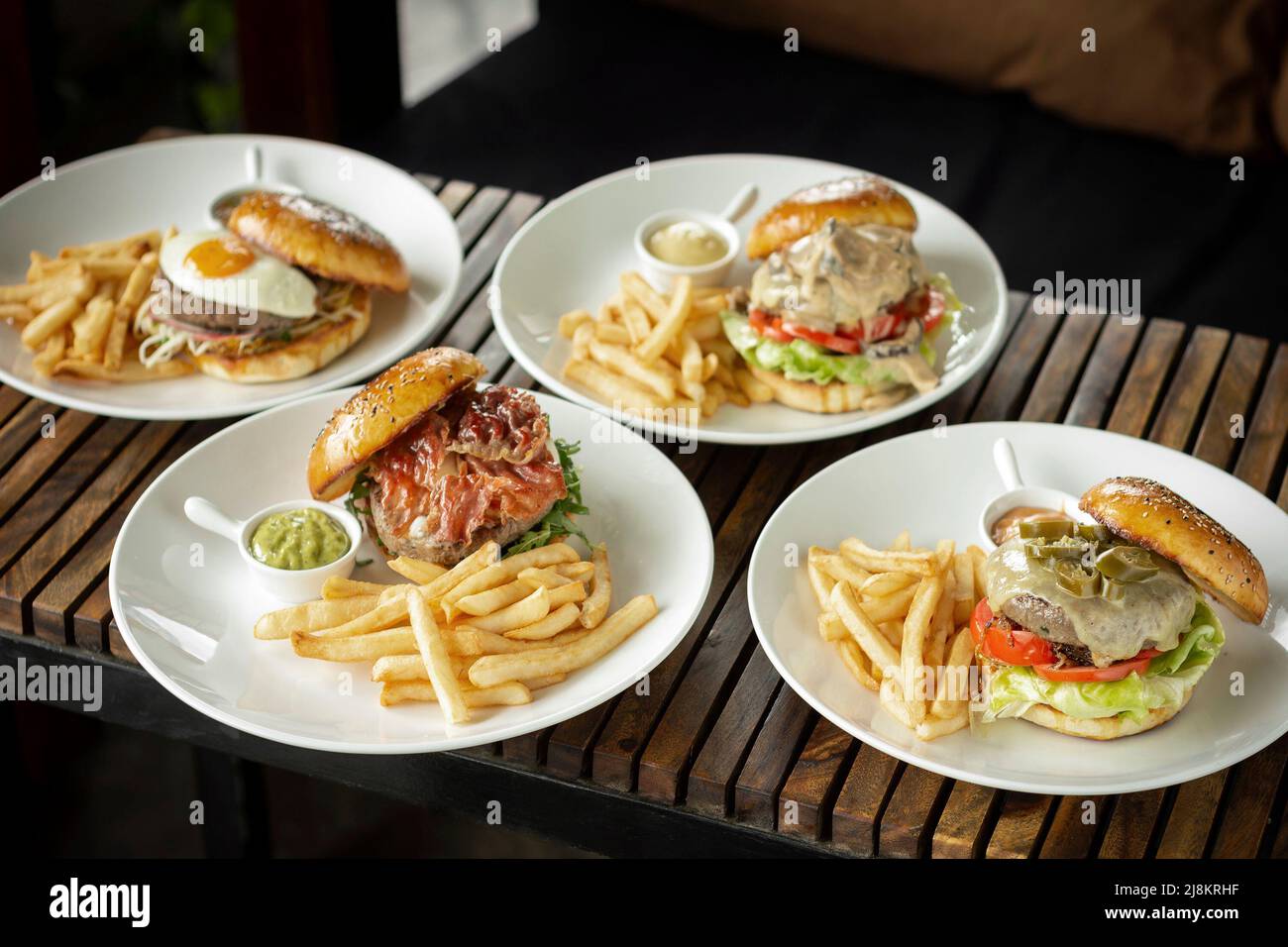 Various different gourmet burgers selection on restaurant wood table ...