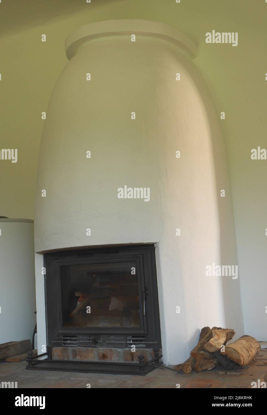 Traditional white plastered wood burning stove in a peasant house ...