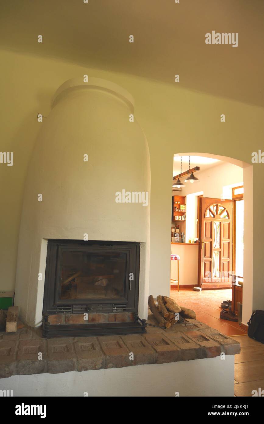 Traditional white plastered wood burning stove in a peasant house ...