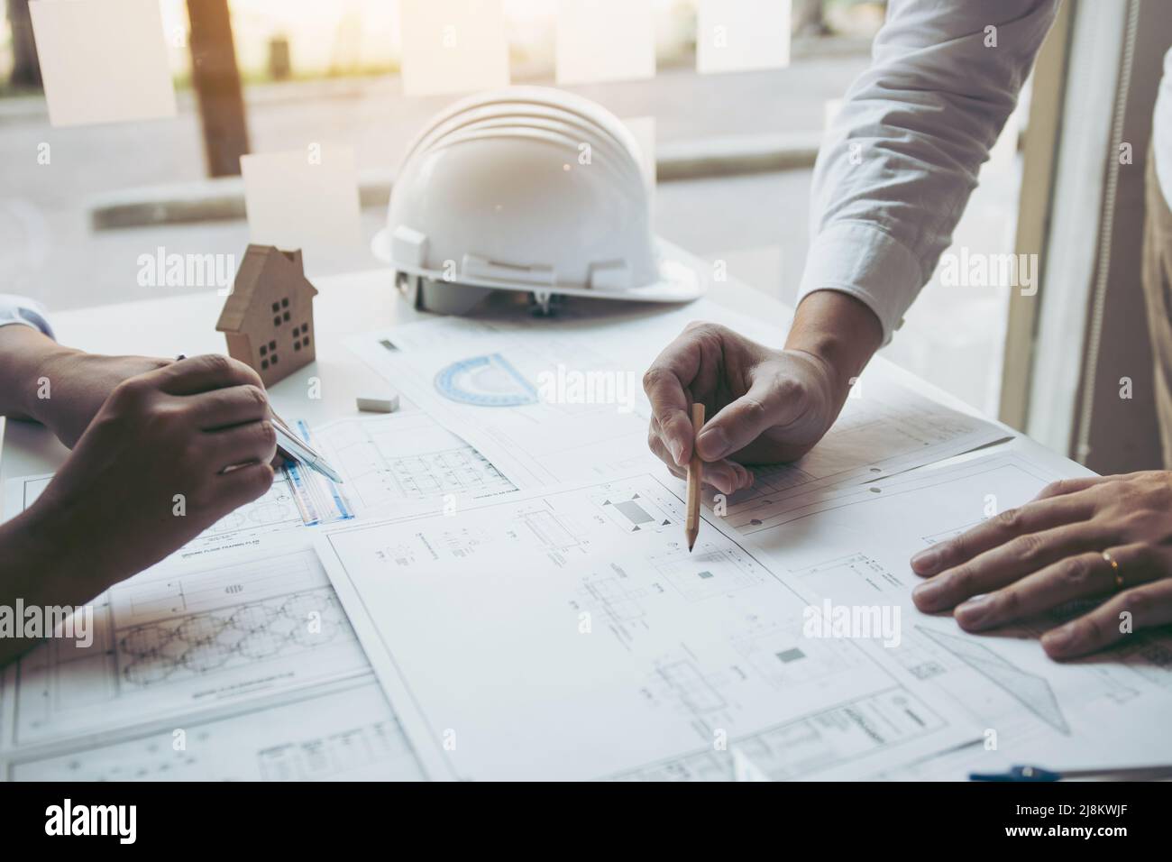 Engineering man showing blueprint detail for people buying house Stock ...