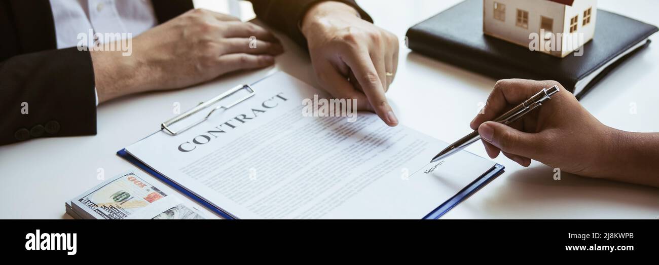 Business people home sales broker is using a pen pointing to the house ...